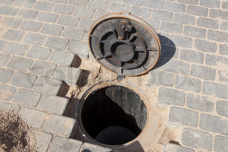 An open sewer hole in a brick paved ... | Stock image | Colourbox