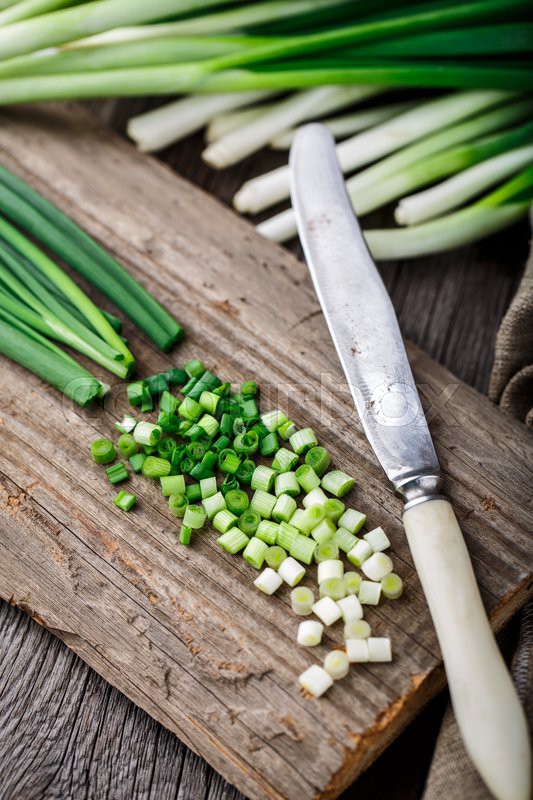 Chopped scallions on a rustic wooden ... | Stock image | Colourbox