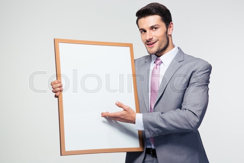 Smiling businessman holding blank board ... | Stock image | Colourbox