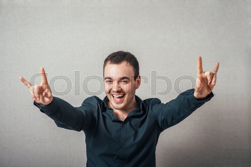 The man is dancing with joy. On a gray ... | Stock image | Colourbox