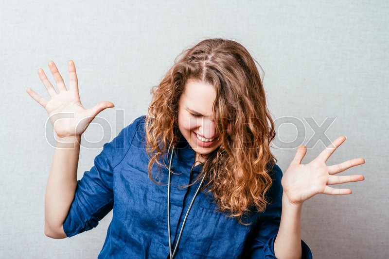 Curly woman smiling, hand in hand. Gray background. | Stock Photo ...