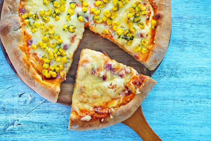 Fresh pizza with cheese and corn on the ... | Stock image | Colourbox