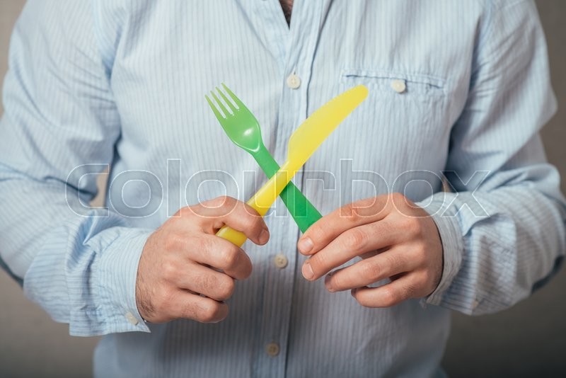 Young happy man holding a fork and a ... | Stock image | Colourbox