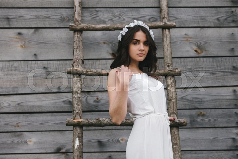A girl sits on a wooden ladder and ... | Stock image | Colourbox