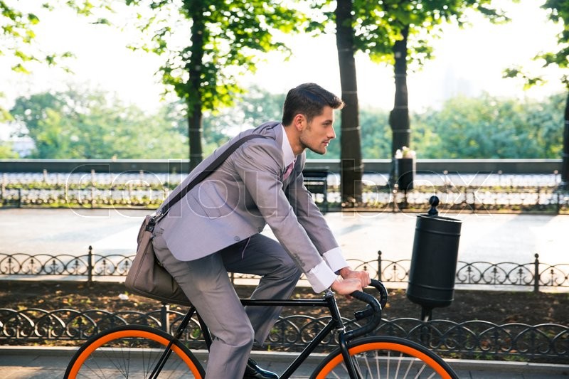 Businessman riding bicycle to work in ... | Stock image | Colourbox