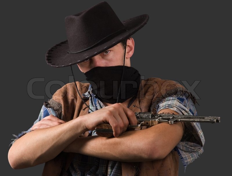 Cowboy with revolver isolated on grey ... | Stock image | Colourbox