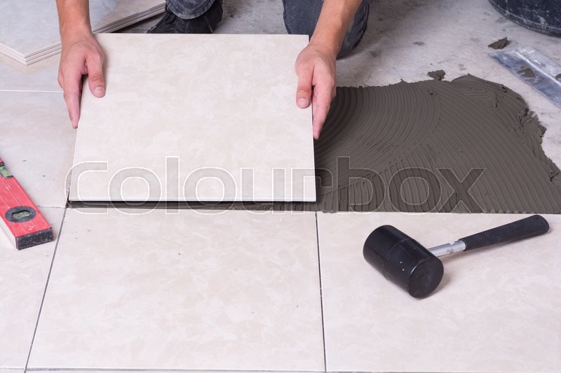 Tiler installing ceramic tiles on a ... | Stock image | Colourbox