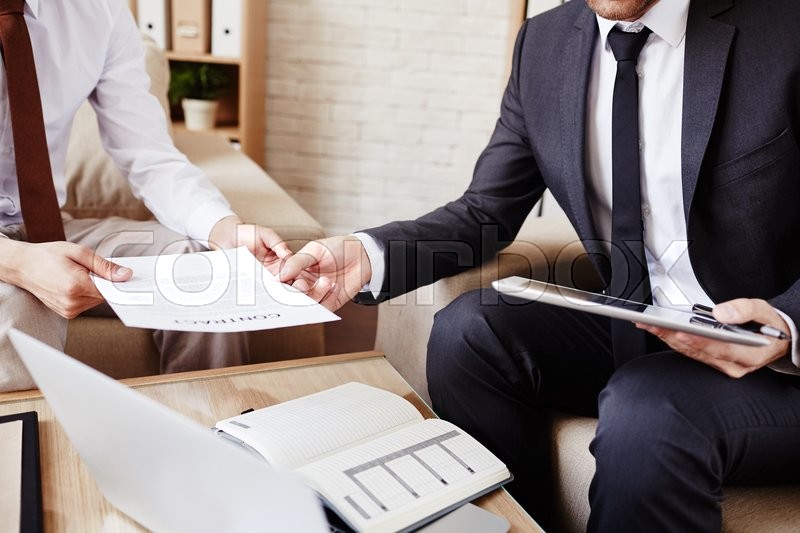 Businessman giving document to his ... | Stock image | Colourbox