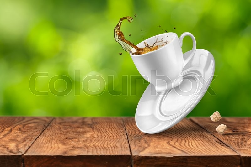Splash of tea in the falling cup on ... | Stock image | Colourbox