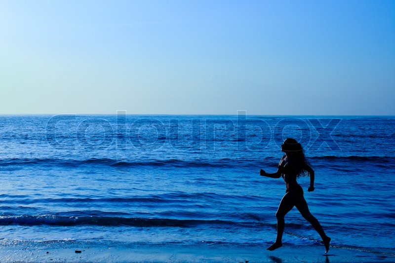 Female running along the beach at ... | Stock image | Colourbox