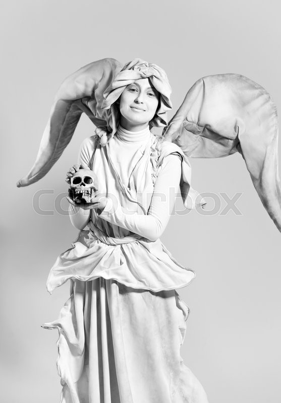 Cupid girl with skull in hands posing ... | Stock Photo | Colourbox