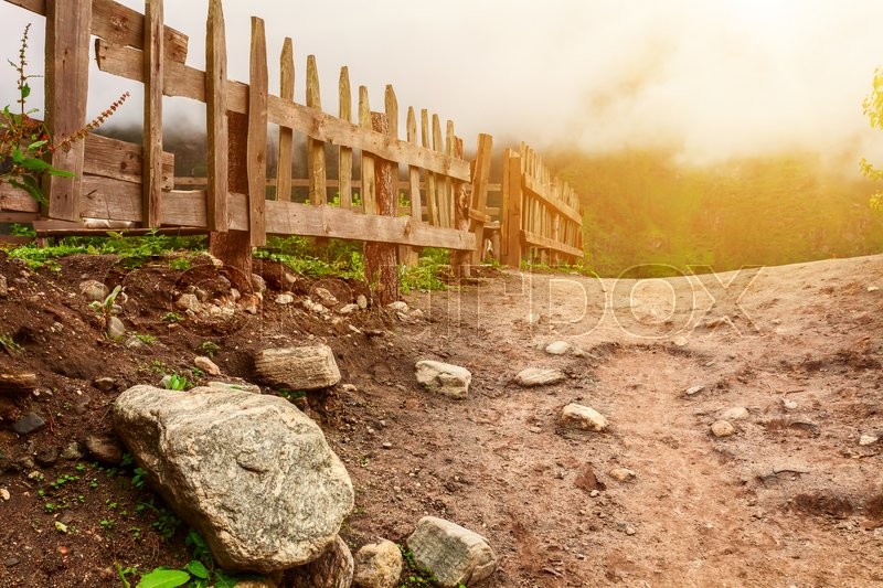 Dirt ground road with rocks and wooden ... | Stock image | Colourbox