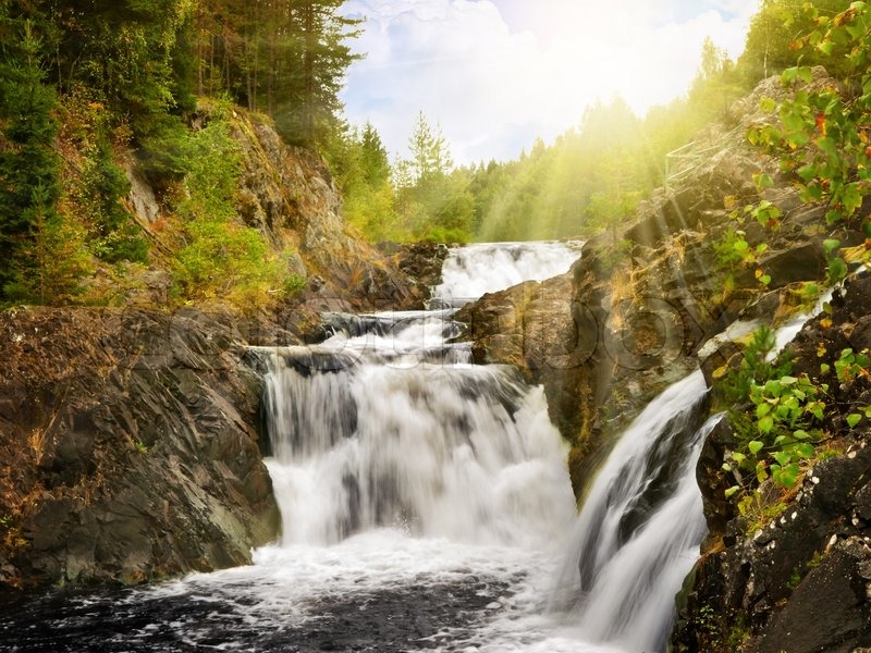 Waterfall between rocks in sunny forest ... | Stock image | Colourbox