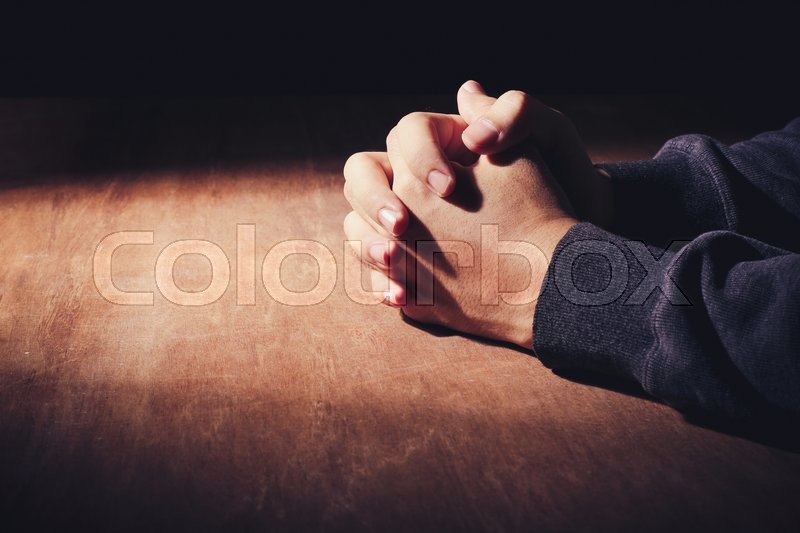 Praying hands of young man on a wooden ... | Stock image | Colourbox