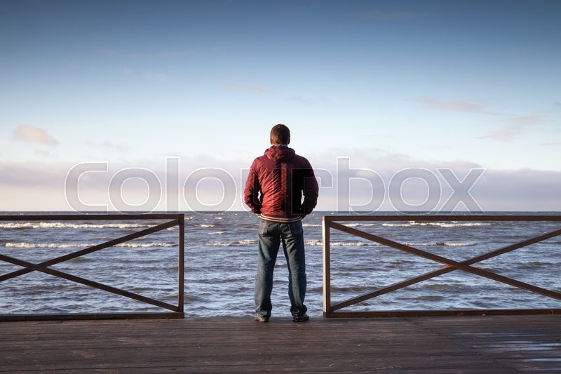 Young man looking on the sea from ... | Stock image | Colourbox