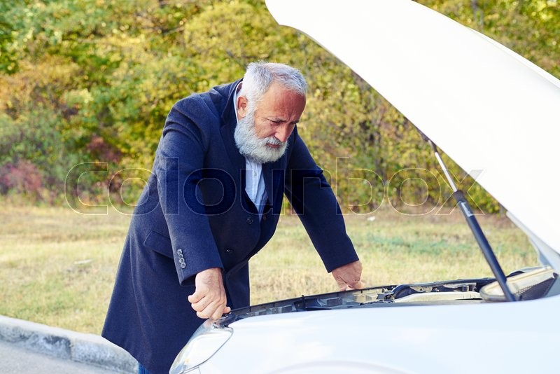 Senior businessman looking under the ... | Stock image | Colourbox