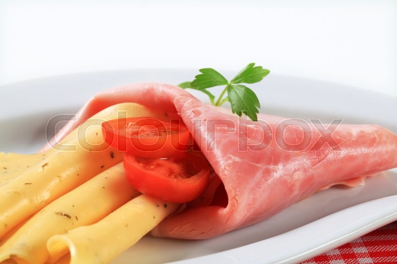 Thinly sliced ham and cheese on a plate | Stock Photo | Colourbox