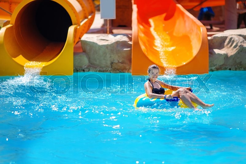 Beautiful girl riding a water slide. | Stock image | Colourbox