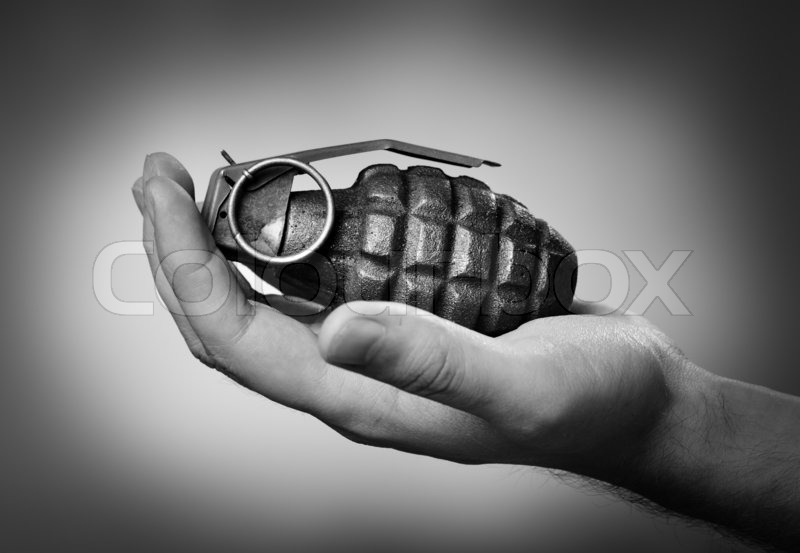 Man holding a hand grenade on his hand. | Stock image | Colourbox