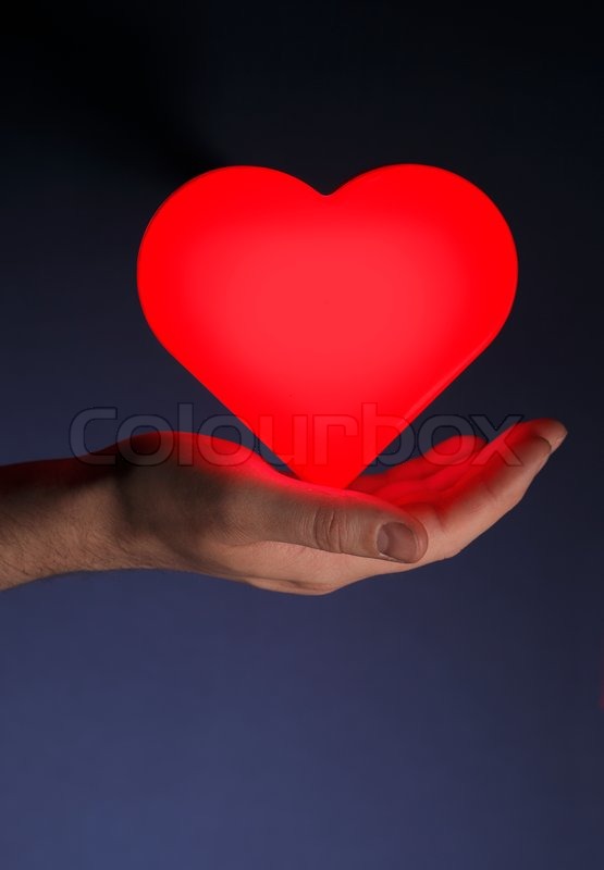 Man holding a red glowing heart shape ... | Stock image | Colourbox