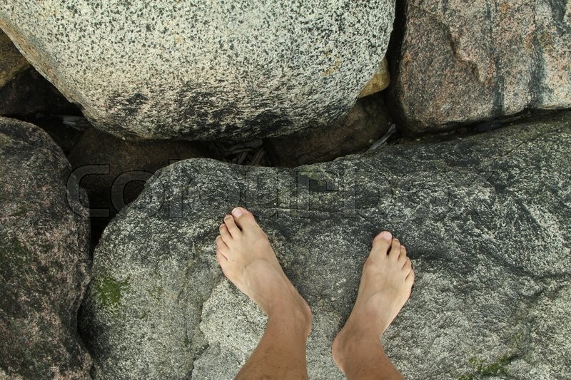 Foot of a man on a rock at the beach of ... | Stock image | Colourbox
