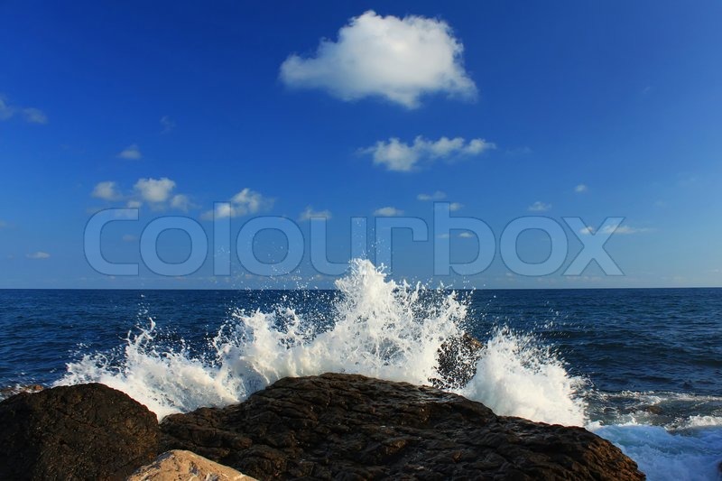 Ocean waves crash against a rock | Stock image | Colourbox