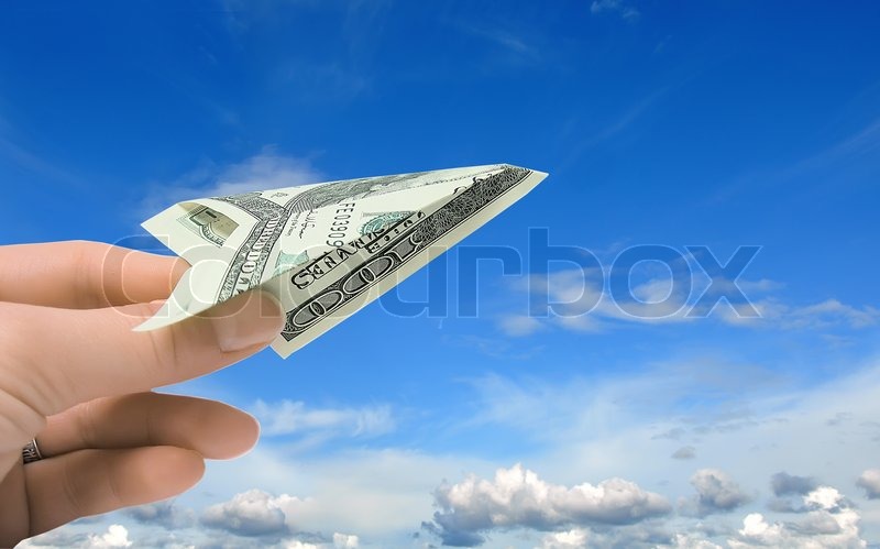 Hand and money plane over blue sky | Stock image | Colourbox