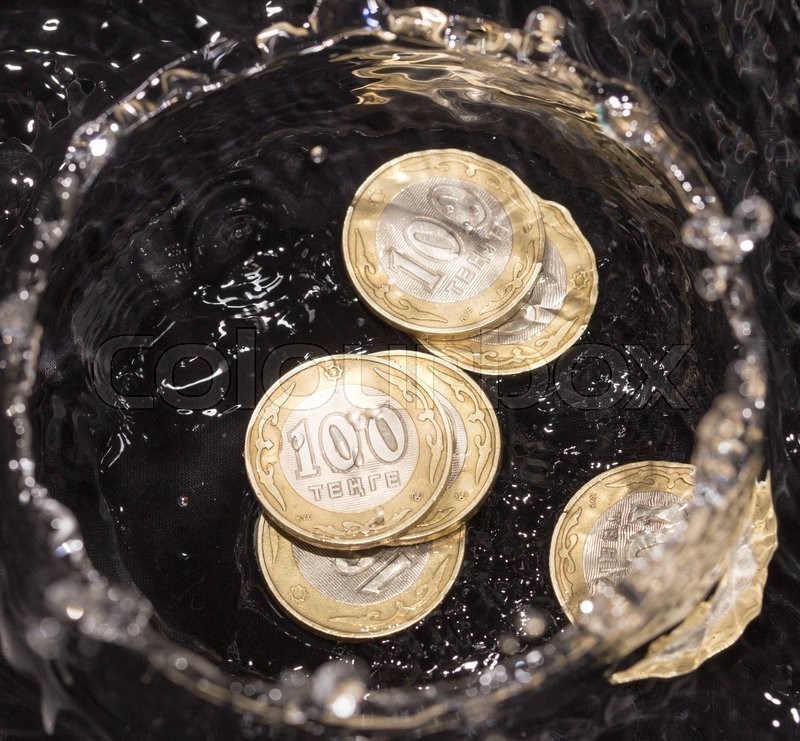 Coins in water splashes on a black ... | Stock image | Colourbox