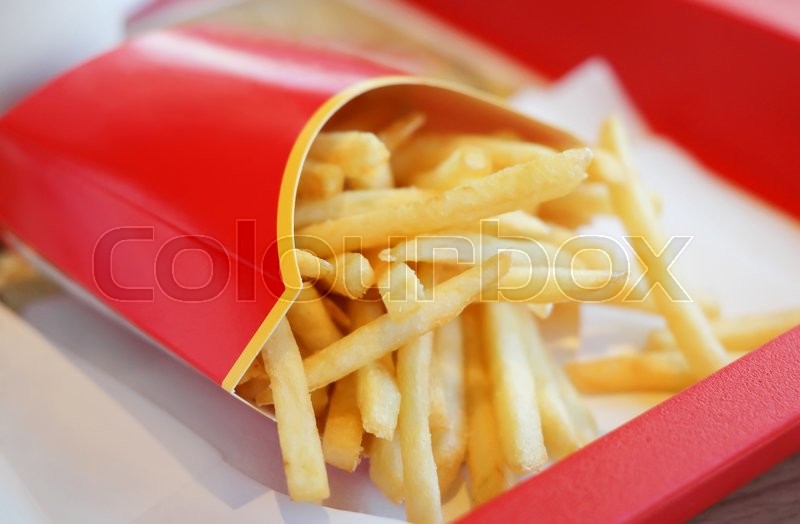 Golden crunchy french fries in red ... | Stock image | Colourbox