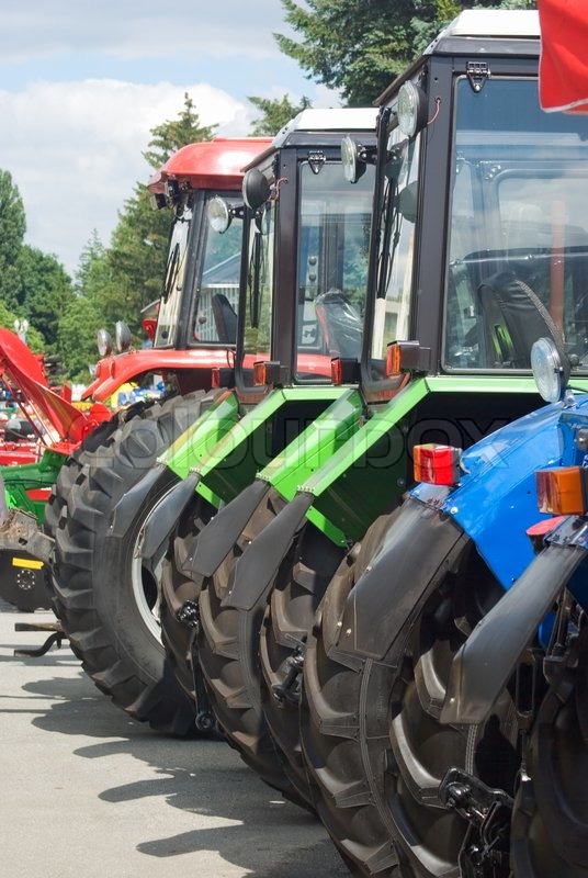 New tractors standing in a row, ready ... | Stock image | Colourbox