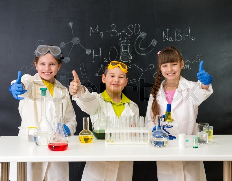 Three little students on chemistry lesson in lab doing an experiment ...