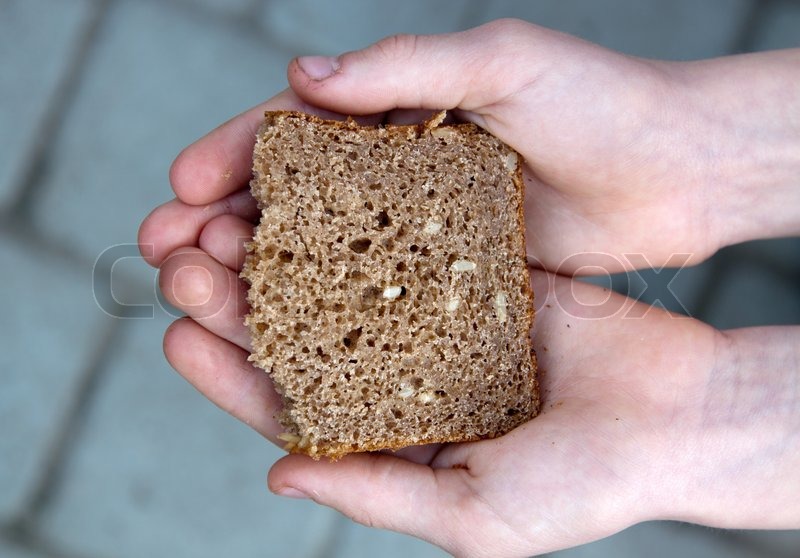 A child holding a piece of bread | Stock image | Colourbox