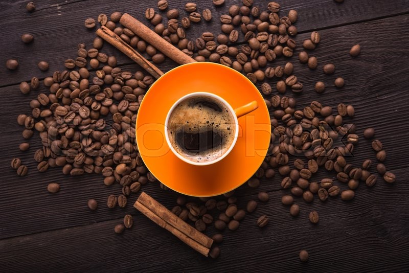 Orange cup of coffee on wooden table | Stock image | Colourbox
