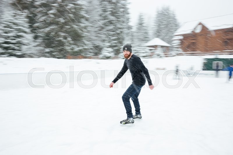 Man ice skating outdoors with snow on ... | Stock image | Colourbox