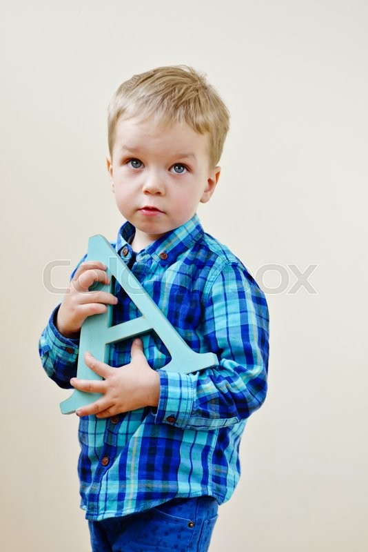 Toddler boy is standing with letter A | Stock image | Colourbox