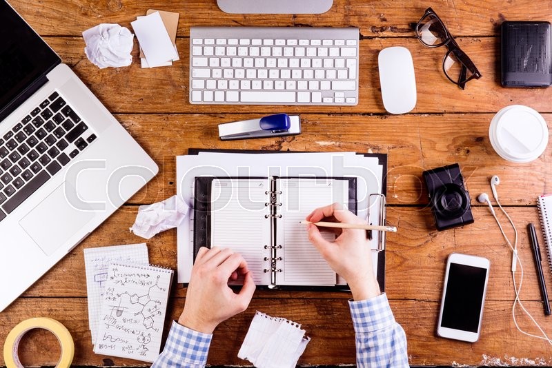 Business person at office desk writing ... | Stock image | Colourbox