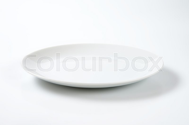 Empty rimless white plate on off-white ... | Stock image | Colourbox