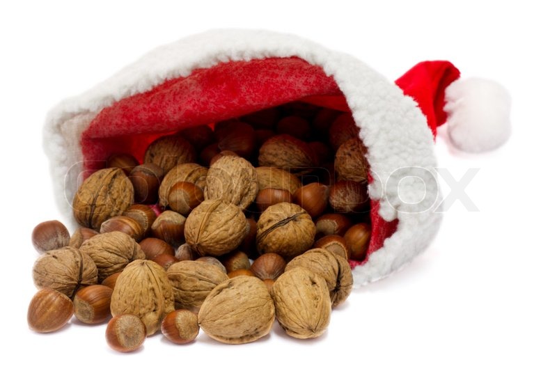 Santa hat filled with nuts over white ... | Stock image | Colourbox