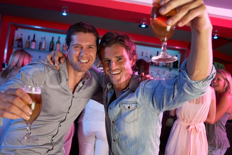 Two Young Men Having Fun In Busy Bar | Stock image | Colourbox