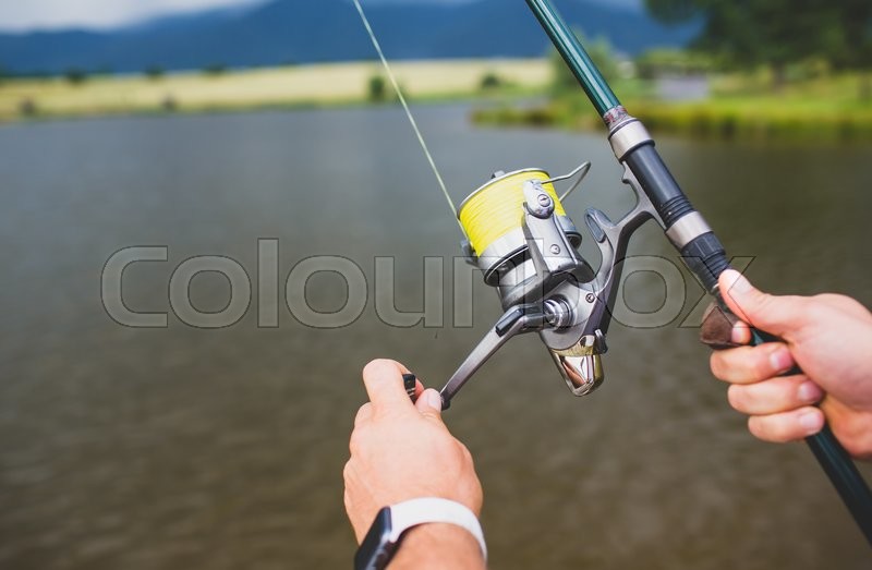 Man holding a fishing-rod on the ... | Stock image | Colourbox
