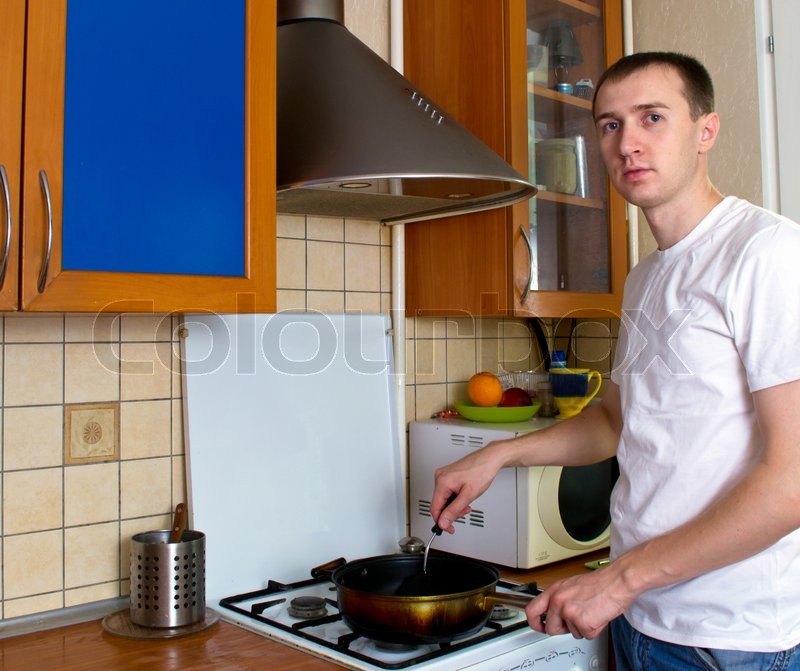 Adult man cooking at the kitchen alone | Stock image | Colourbox