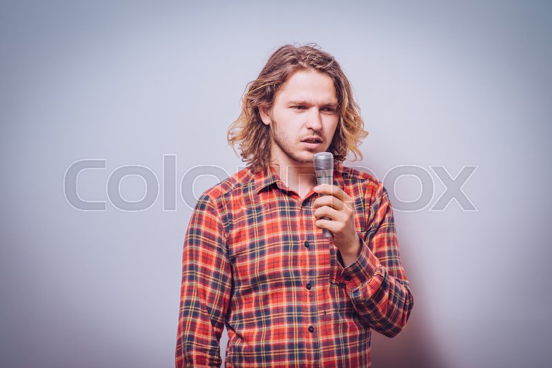 Handsome man singing to the microphone. ... | Stock image | Colourbox