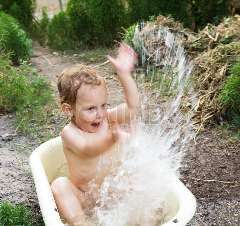 Boy bathing in the tub splashing water | Stock image | Colourbox