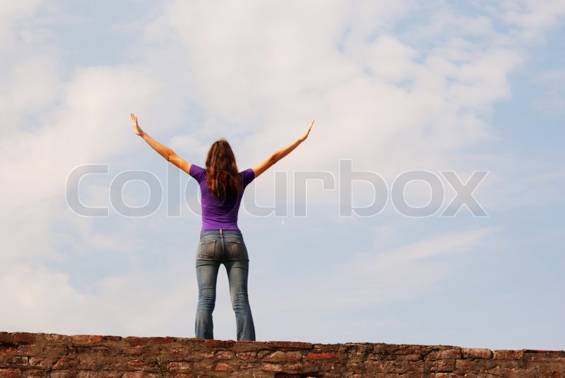 Young woman staying with raised hands ... | Stock image | Colourbox