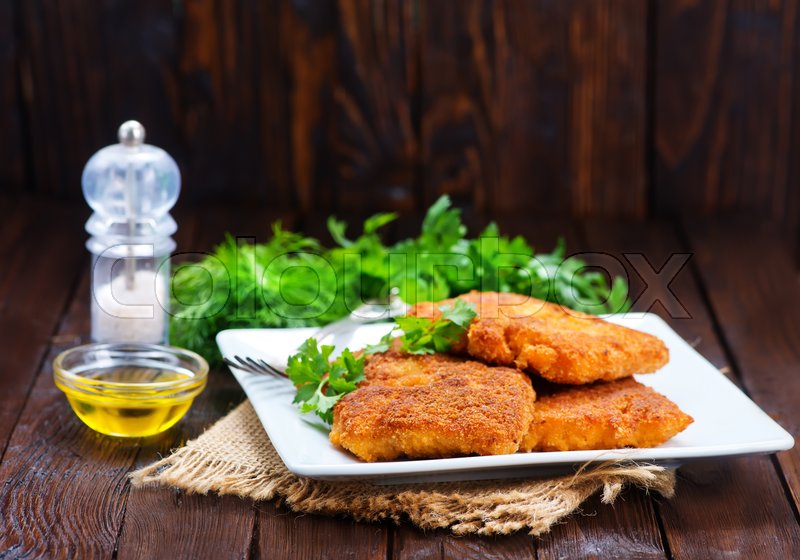 Fried fish on plate and on a table | Stock image | Colourbox