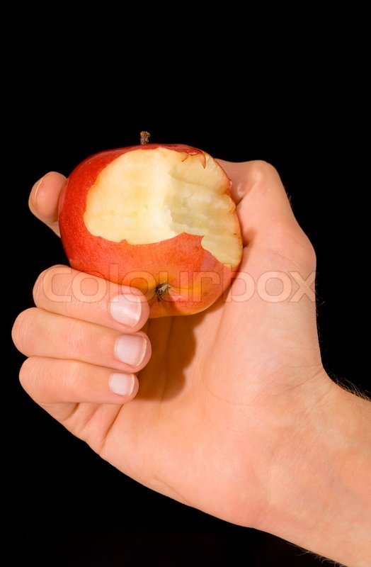 Man's hand holding a bitten apple on ... | Stock image | Colourbox