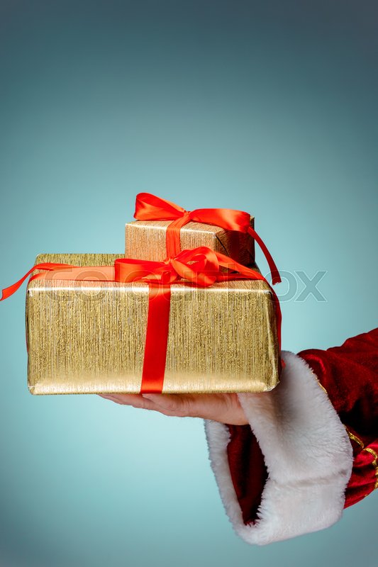 The hand of santa claus holding a gift ... | Stock image | Colourbox
