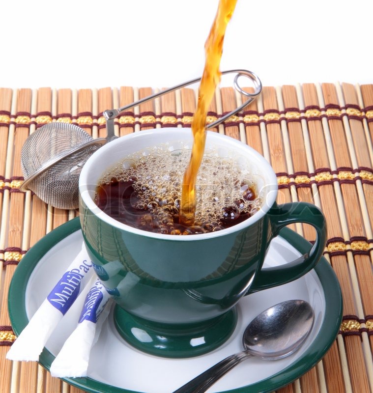 Pouring fresh tea into green cup ... | Stock image | Colourbox