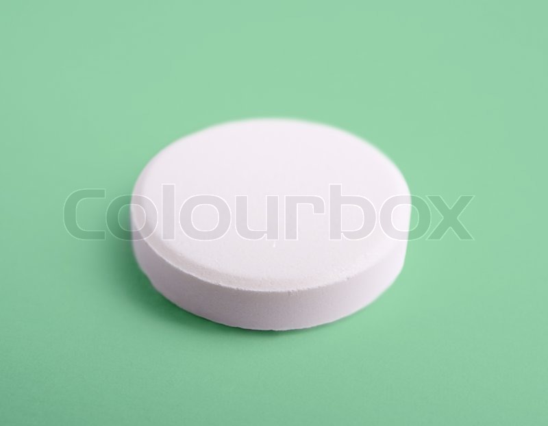 Single white tablet on green ... | Stock image | Colourbox