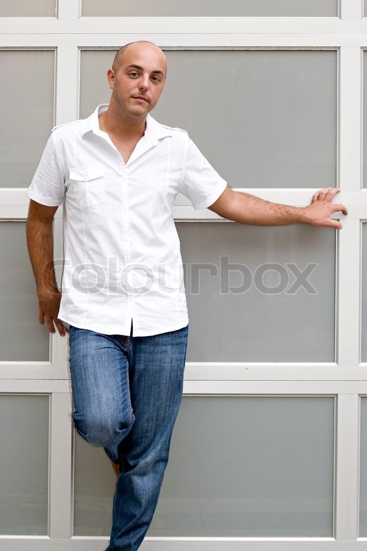 A young man leaning up against a wall ... | Stock Photo | Colourbox